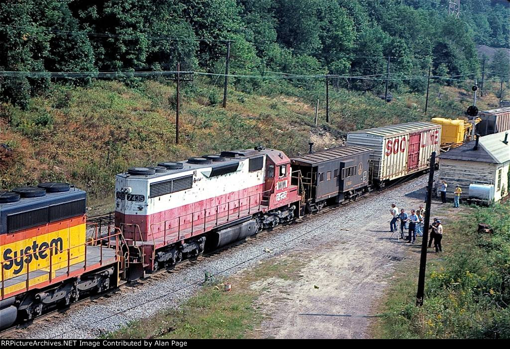 A gathering of railfans watches WM 7435